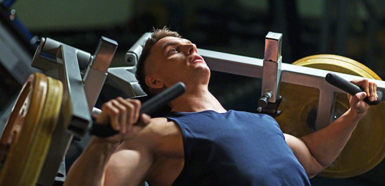 man doing chest press on exercise machine in gym | Zolooz